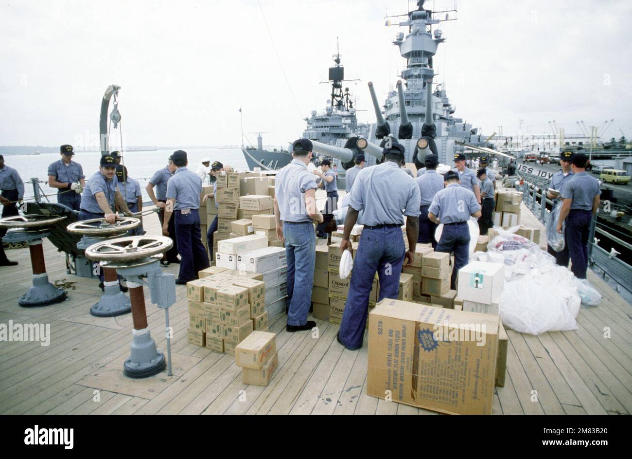 Crew members load Project Handclasp materials aboard the battleship USS ...