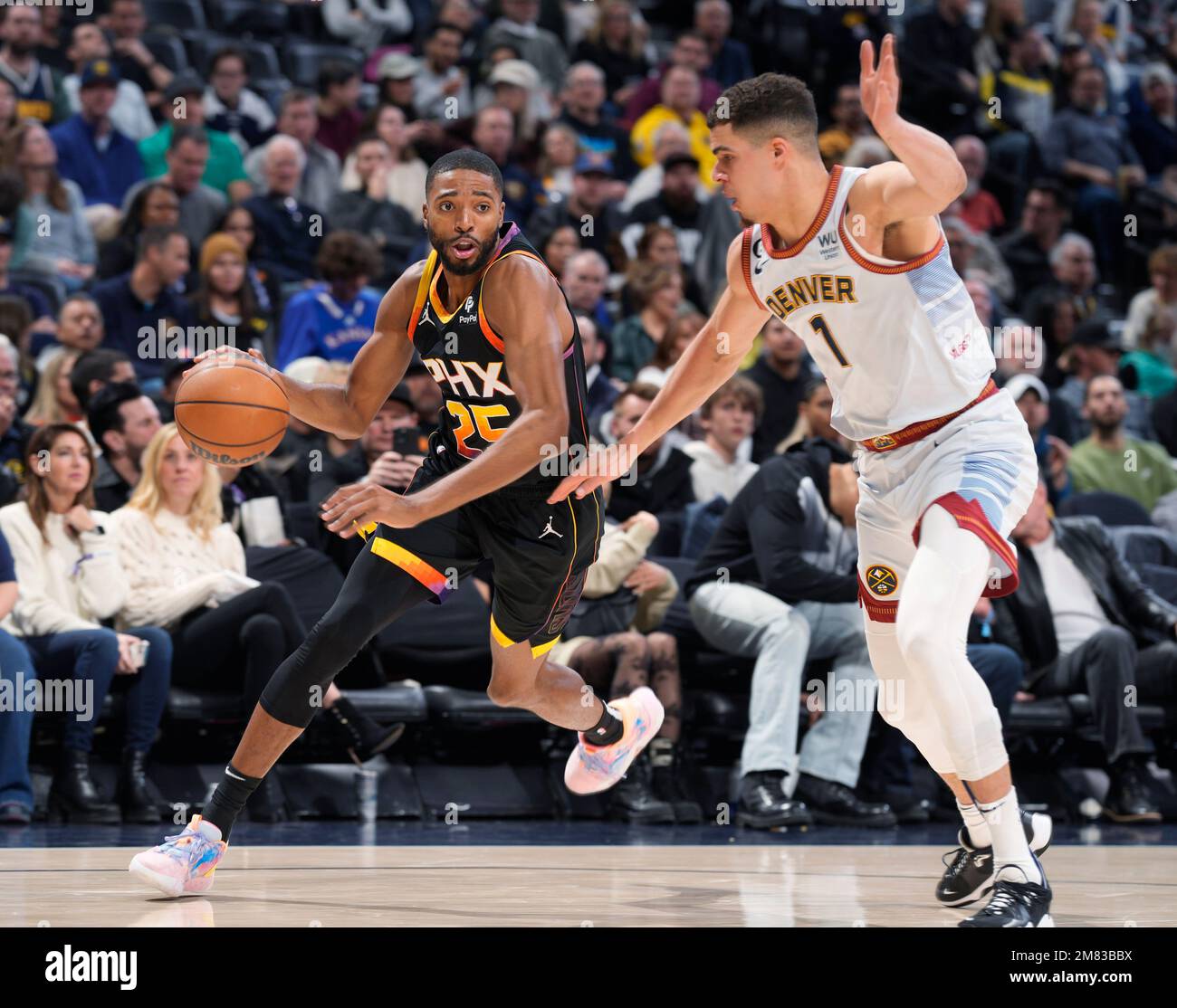 Phoenix Suns forward Mikal Bridges, left, drives against Denver Nuggets ...