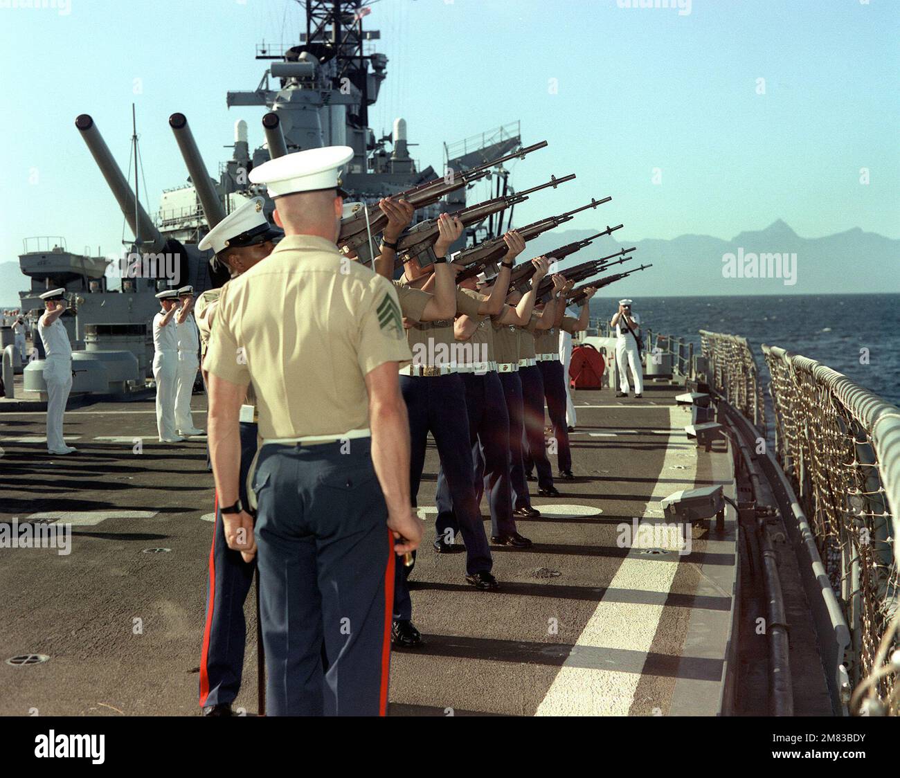 A Marine honor guard aboard the battleship USS IOWA (BB-61) fires a 21 ...