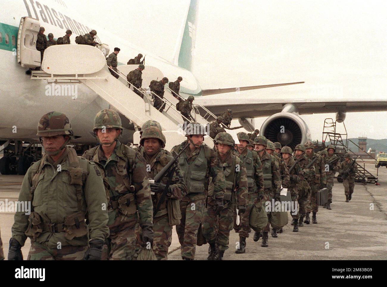 Soldiers of the 25th Inf. Div. exit from a commercial 747 airliner as ...