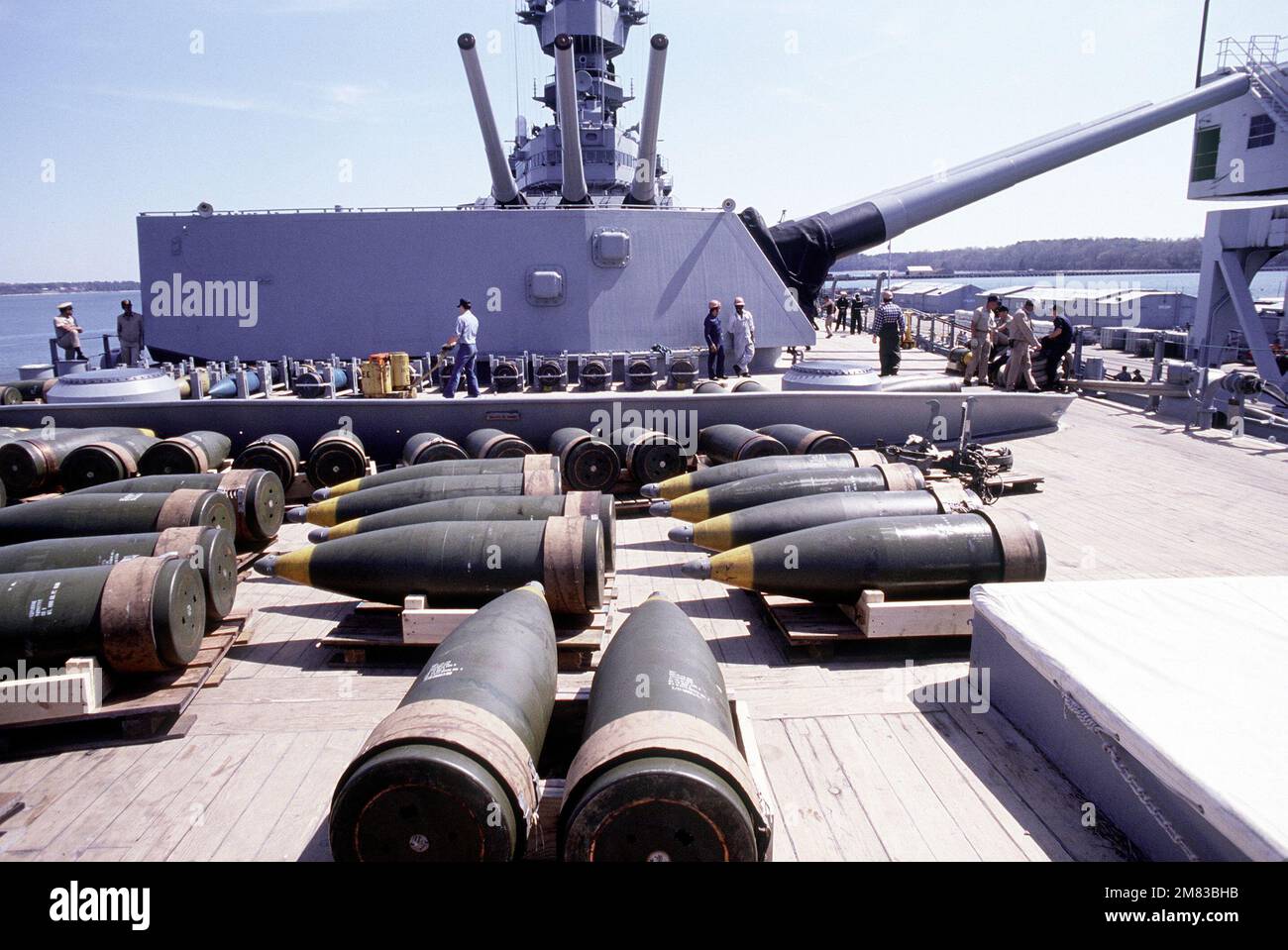 Sixteen-inch projectiles are staged on the deck for offloading from the ...