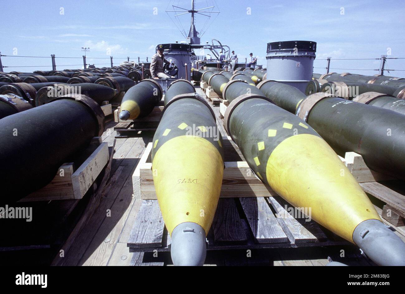 Sixteen-inch projectiles are staged on the deck for offloading from the ...