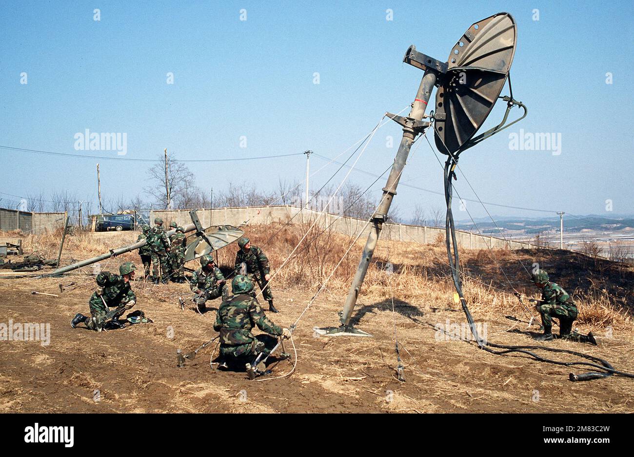 U.S. Air Force technicians raise an AN/TRC-97 parabolic dish wide-band ...