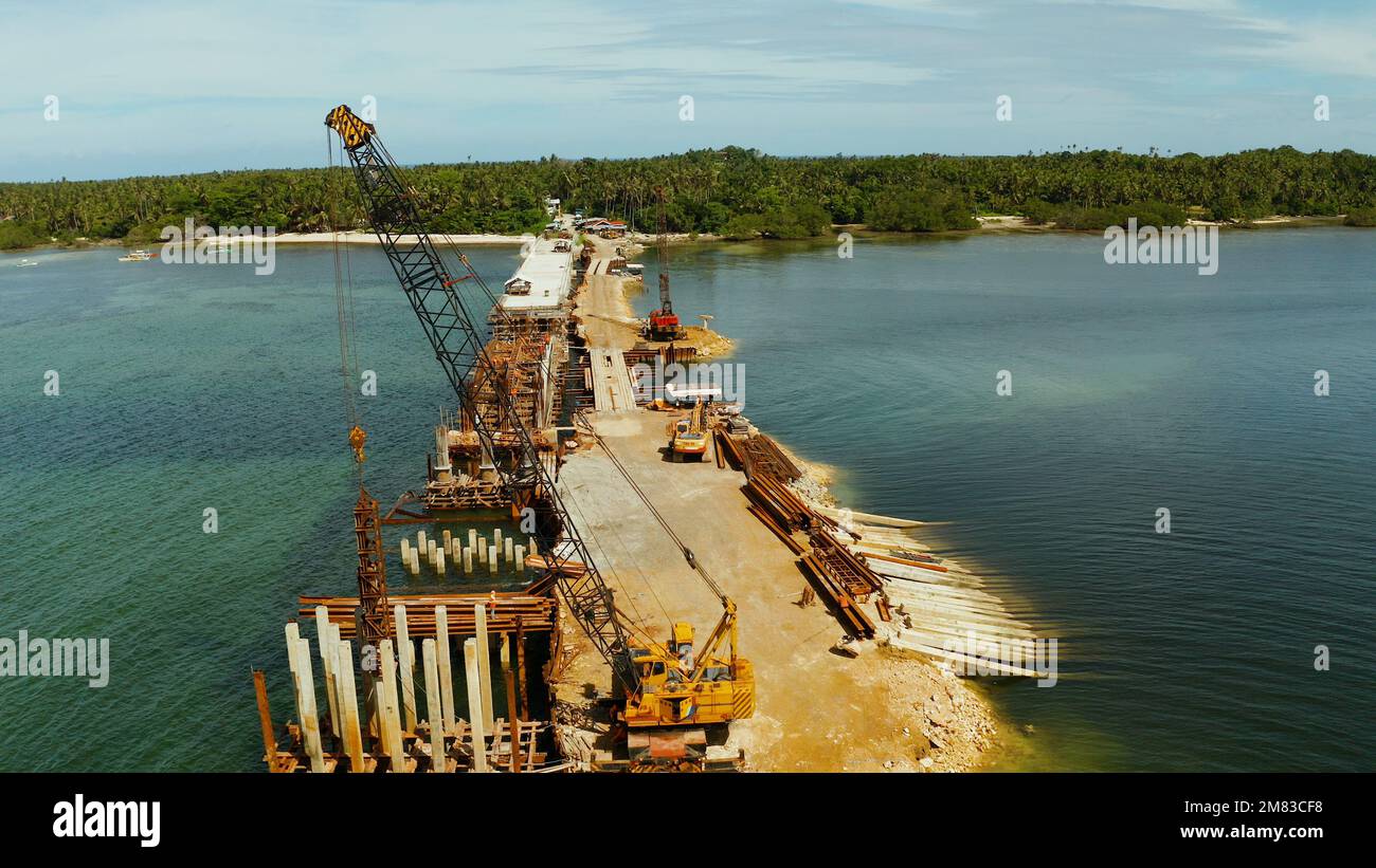 Pile driver hammer in action. Construction bridge over the sea bay on ...