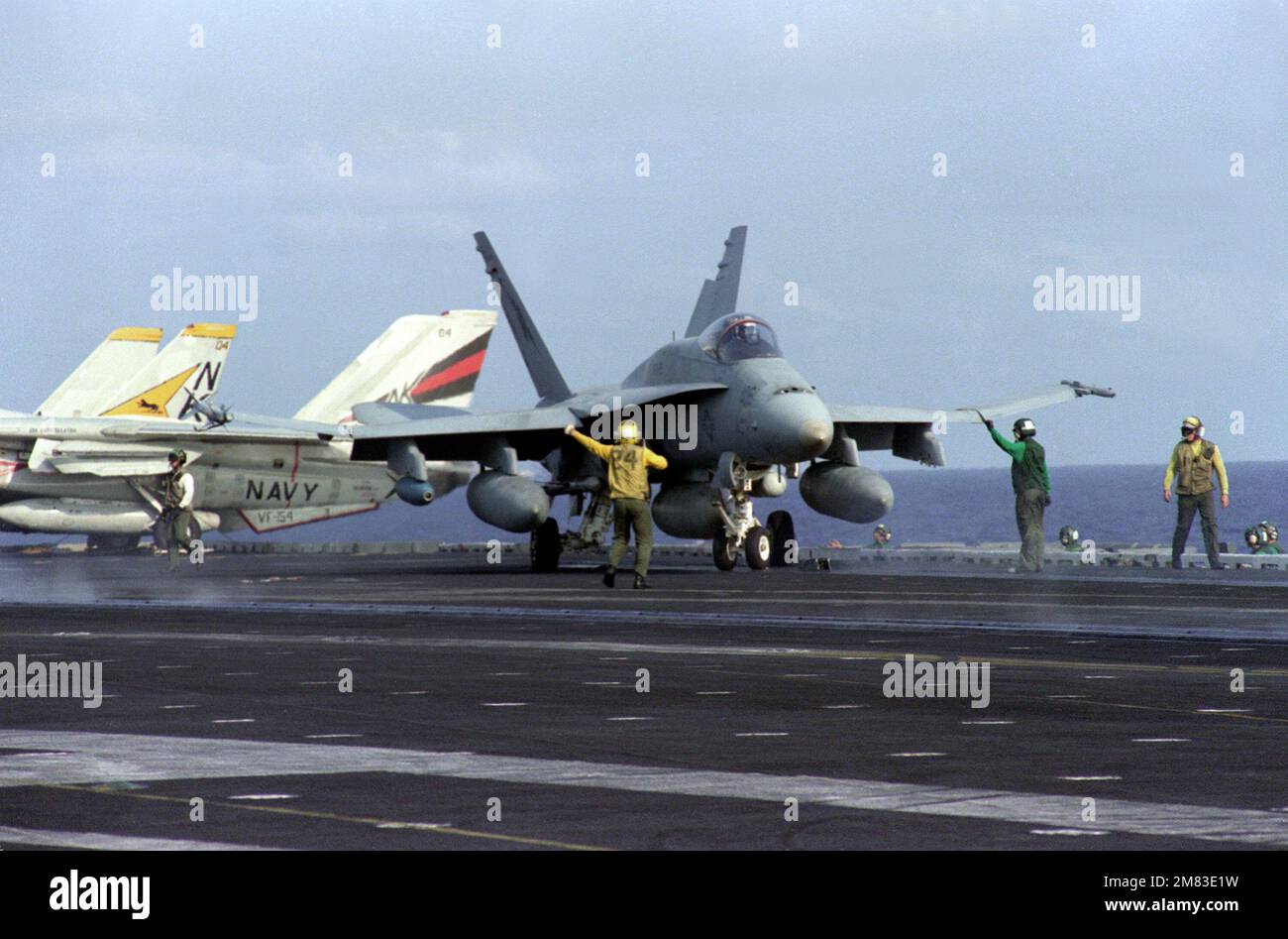 Crewmen prepare an F/A-18 Hornet aircraft from Strike-Fighter Squadron ...