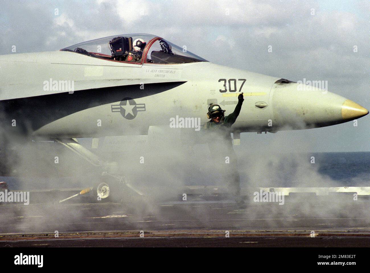 Smoke drifts up from a catapult as an F/A-18 Hornet aircraft from ...