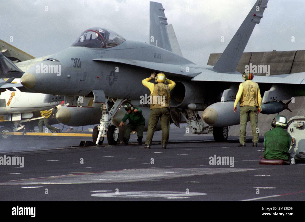 Crewmen prepare an F/A-18 Hornet aircraft for takeoff aboard the ...