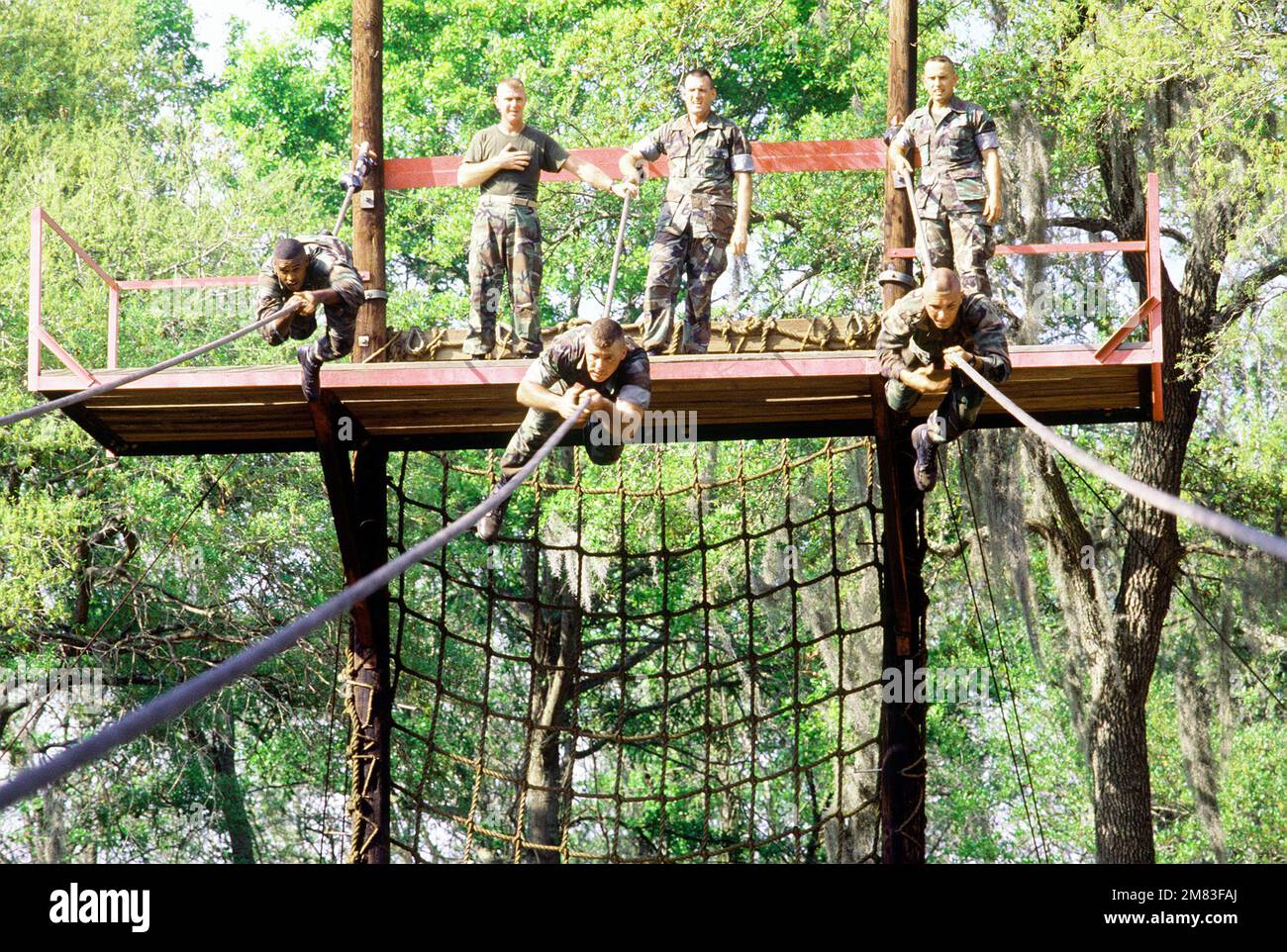 Marine recruits cross a rope on the "slide for life" while running the ...