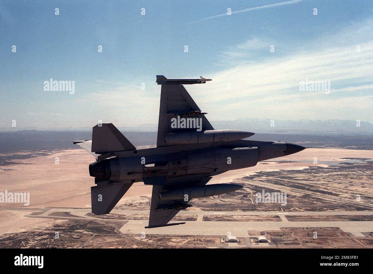An air-to-air right underside view of an F-16C Fighting Falcon aircraft ...