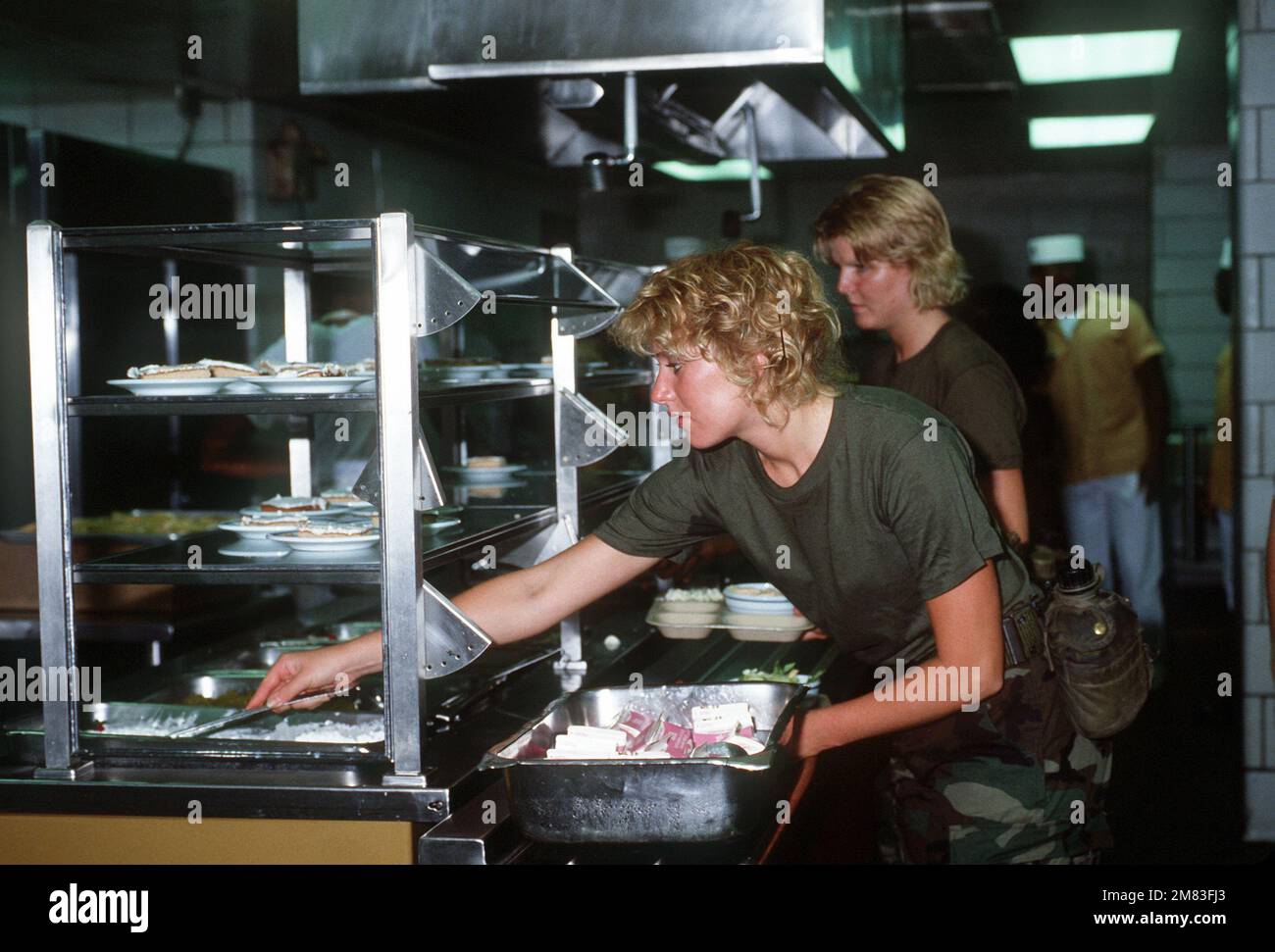Women Marine recruits select food at the mess hall during basic ...