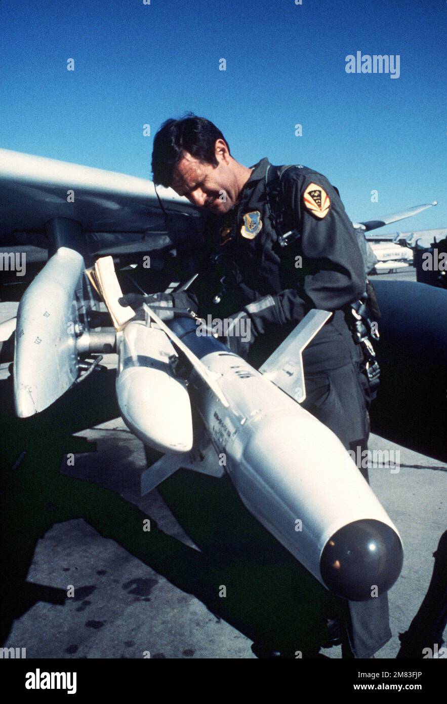 A pilot checks an AIM-9N/P Sidewinder missile aboard an F-4 Phantom II ...