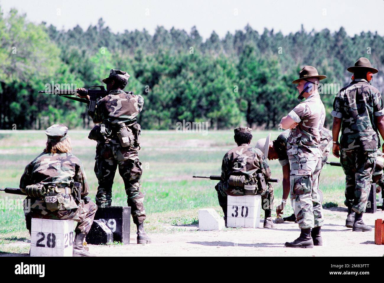 A female Marine recruit fires an M-16A2 rifle during small arms ...