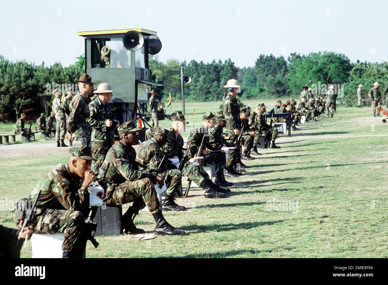 Marine recruits with M-16A2 rifles wait to approach the firing line at ...