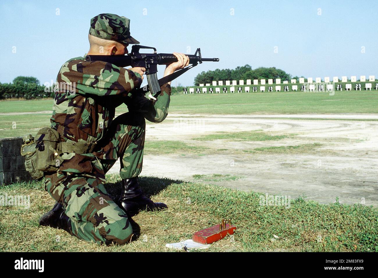 A Marine recruit fires an M-16A2 rifle from a kneeling position during ...