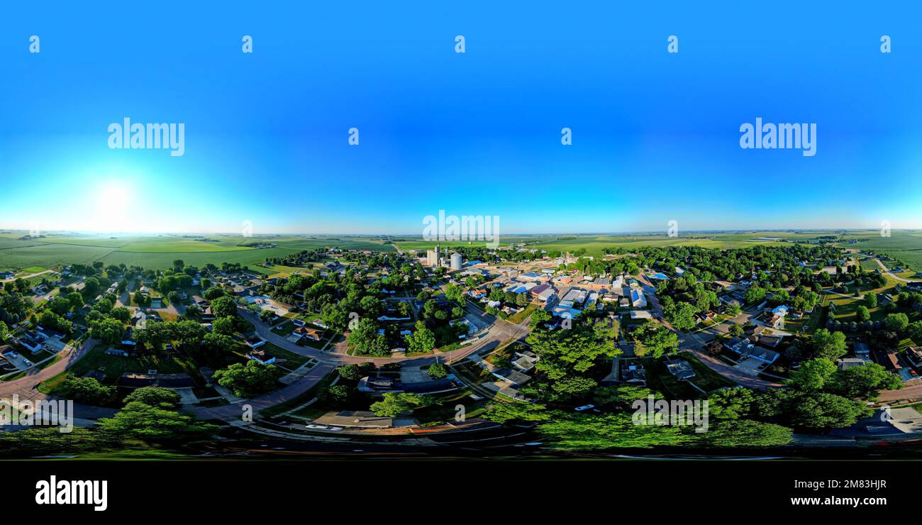 An aerial panoramic view of small town with lush green trees and fields ...