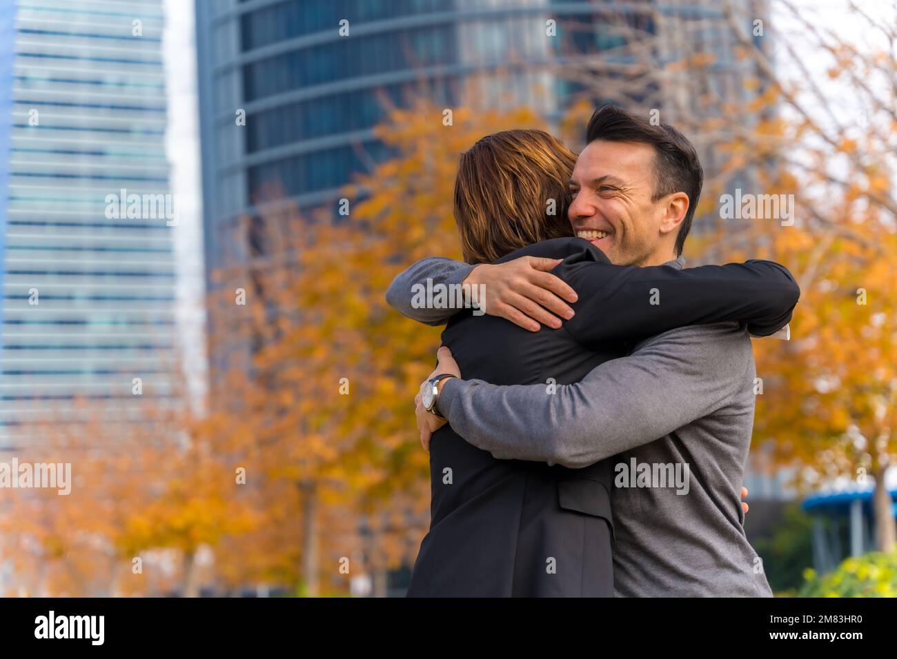A scenic view of two caucasian businessmen hugging each other outside ...