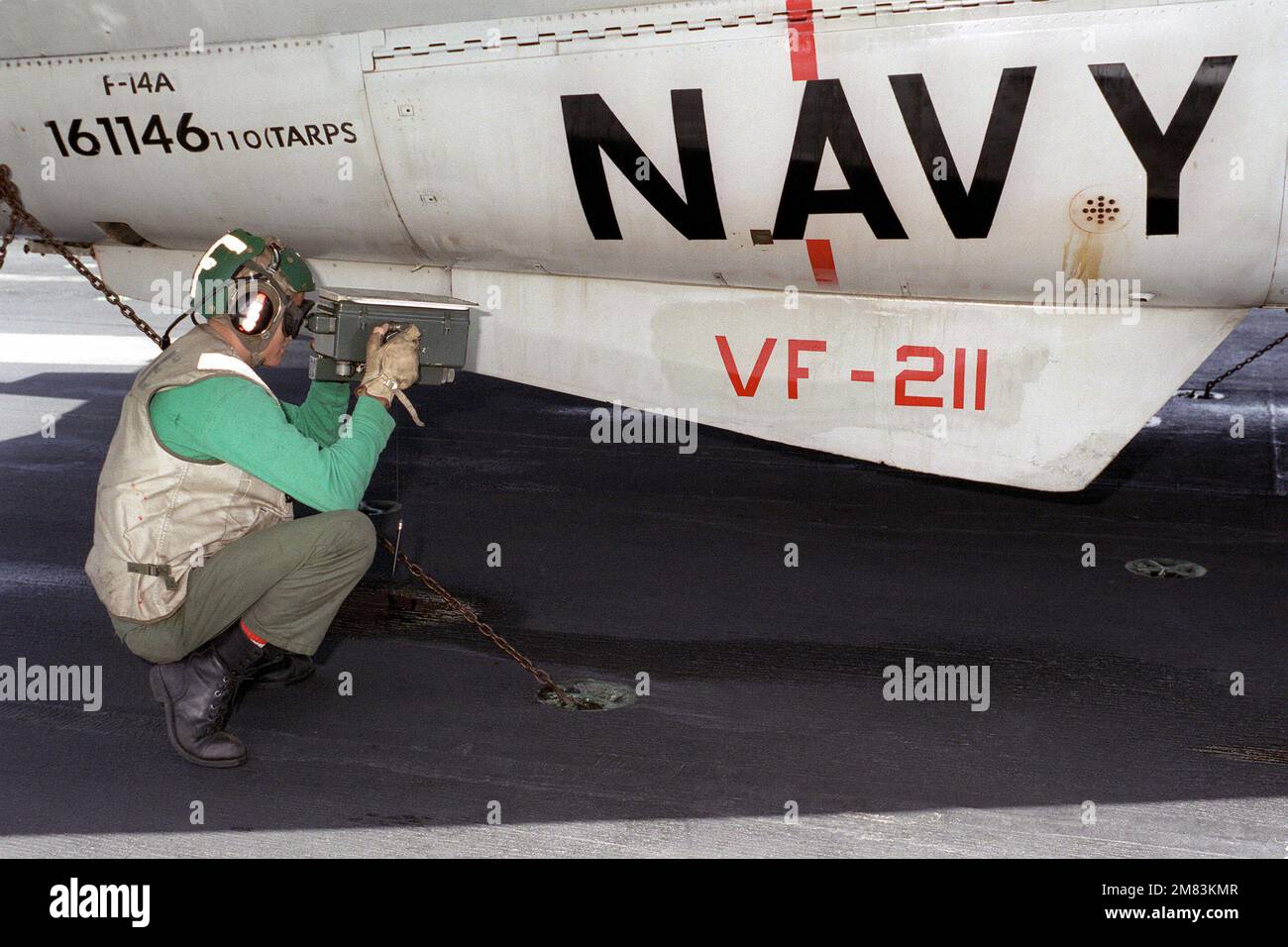 A technician inspects a Figher Squadron 211 (VF-211) F-14A Tomcat ...