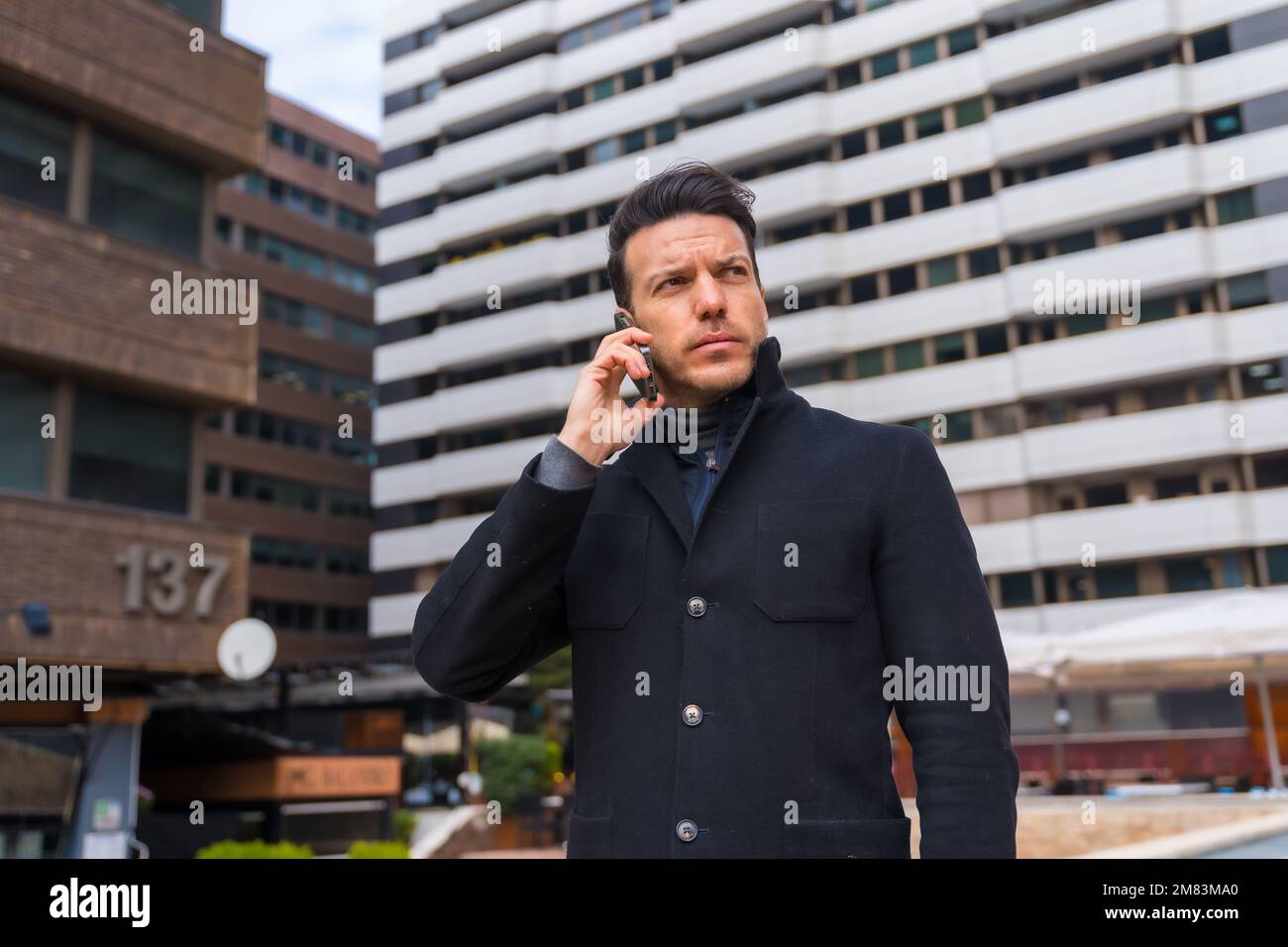 A middle-aged Caucasian businessman talking on the phone in the city ...