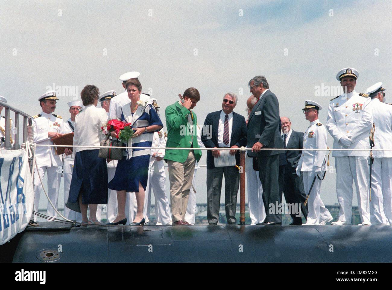 Distinguished guests gather on the deck of the nuclear-powered ...