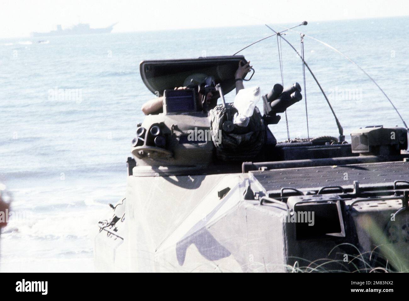 A Marine emerges from the turret of an LVTP-7 tracked landing vehicle ...