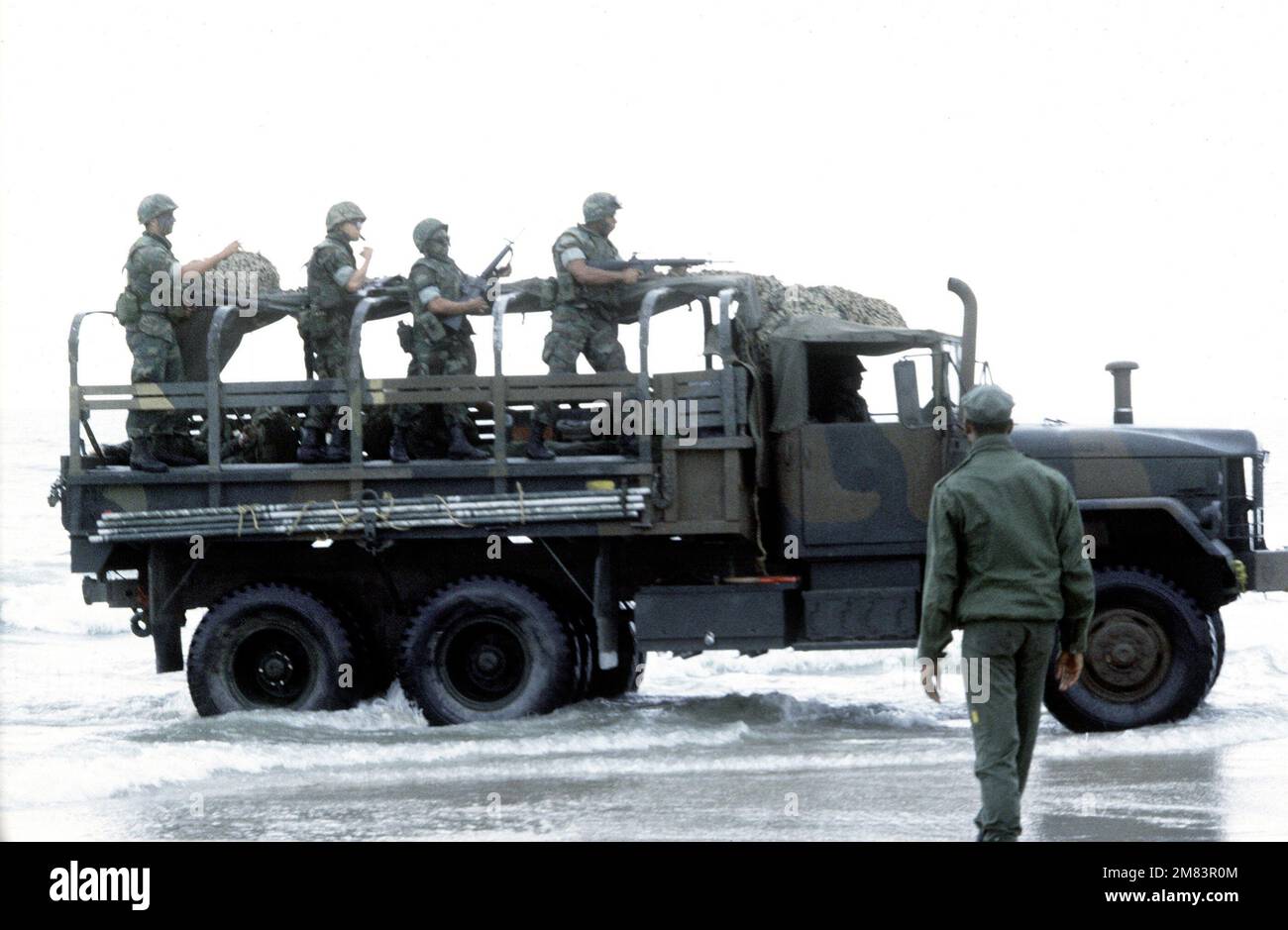 An M-809 5-ton cargo truck carrying Marines is driven onto Onslow Beach ...