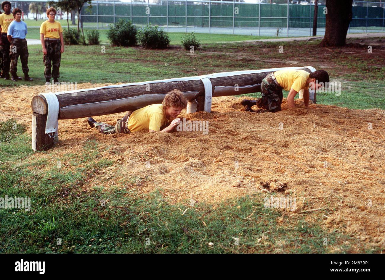Women Marine recruits crawl under an obstacle on the challenge course ...