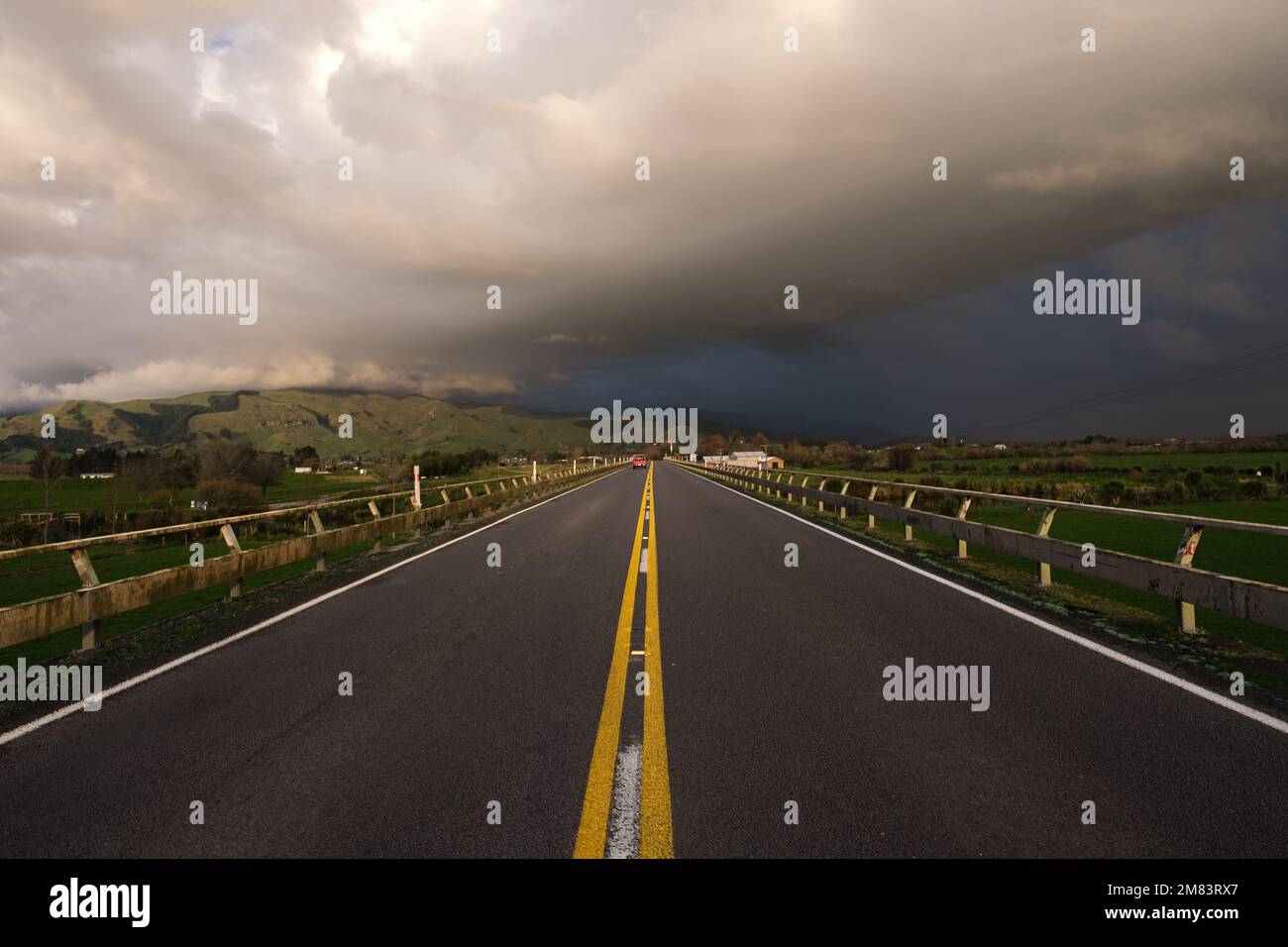 Road heading from sunshine towards a wet weather rain front Stock Photo ...