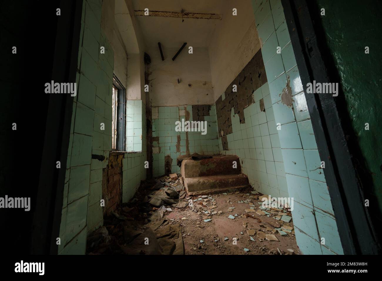 Interior of grungy room with weathered concrete steps and broken tiles ...
