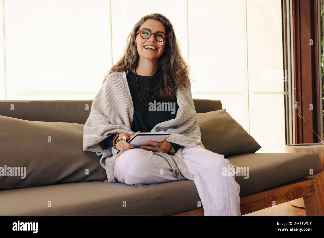 Journaling and mental wellbeing. Mature woman smiling happily while ...