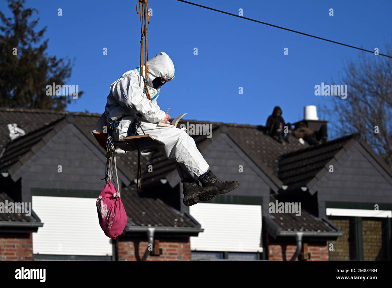 Erkelenz, Germany. 11th Jan, 2023. A demonstrator sits on a swing under ...