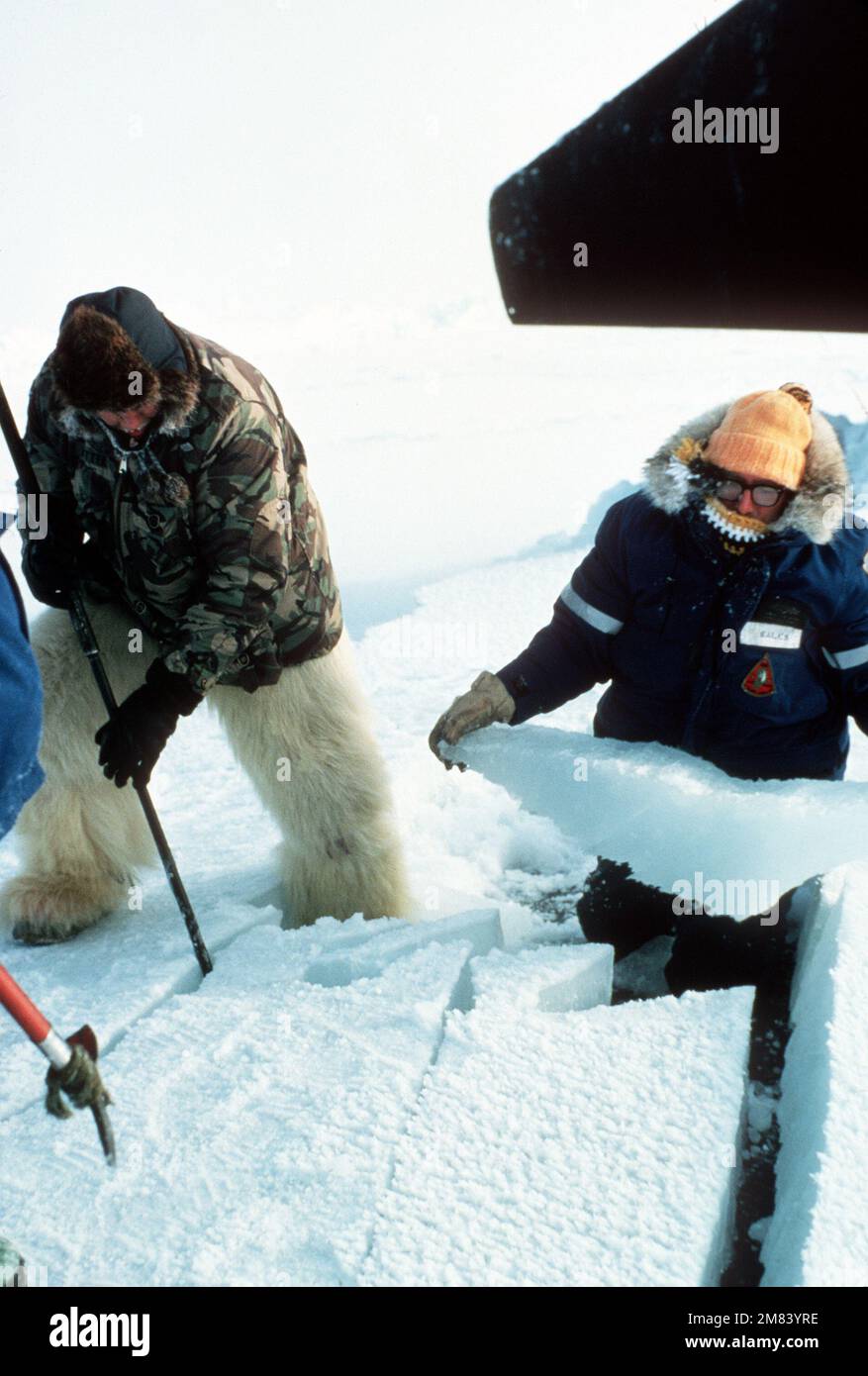 Ice is cleared from the hatch of the nuclear-powered submarine USS ...