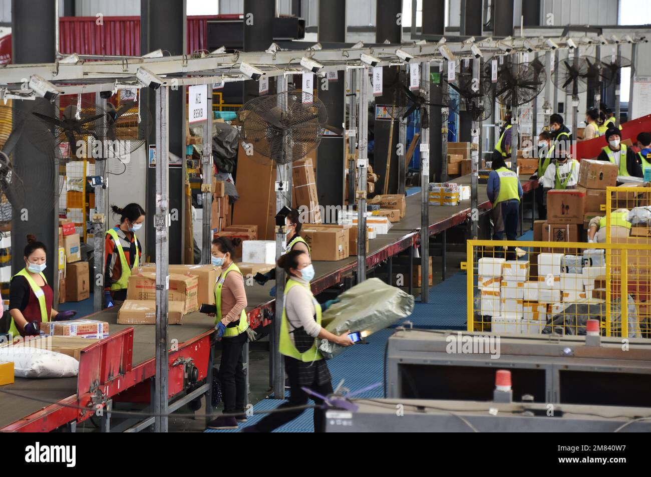 QIANDONGNAN, CHINA - JANUARY 12, 2023 - Workers sort deliveries at a ...