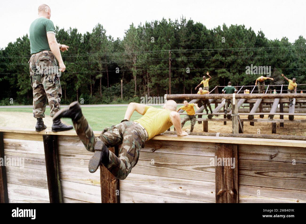 An instructor observes Marine recruits on the obstacle course during ...
