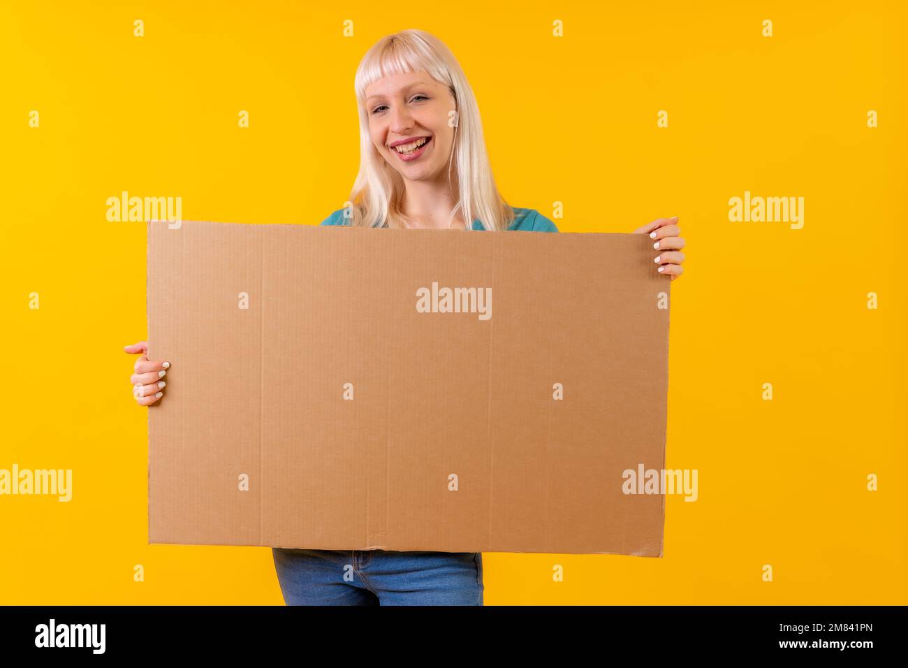 A blonde Caucasian woman holding a cardboard advertisement poster with ...
