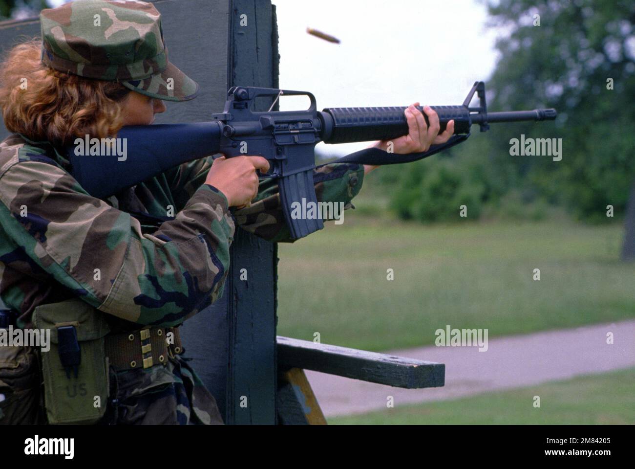 A woman Marine recruit fires an M-16A2 rifle from a standing position ...