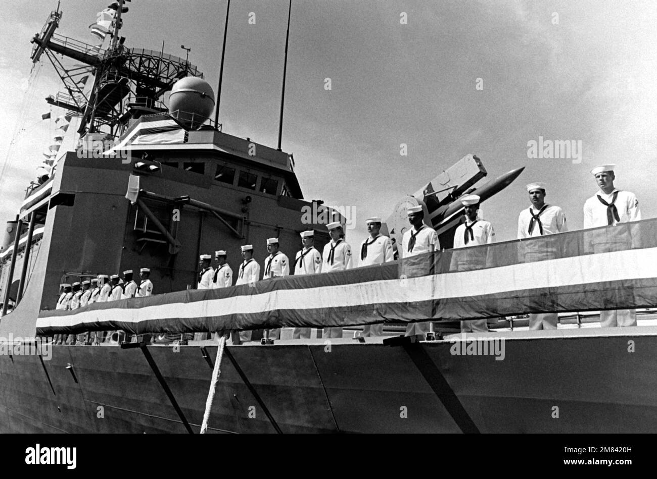 Crew members man the rail during the commissioning of the guided ...