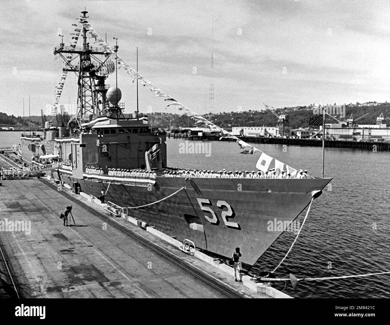 Crew members man the rail during the commissioning of the guided ...