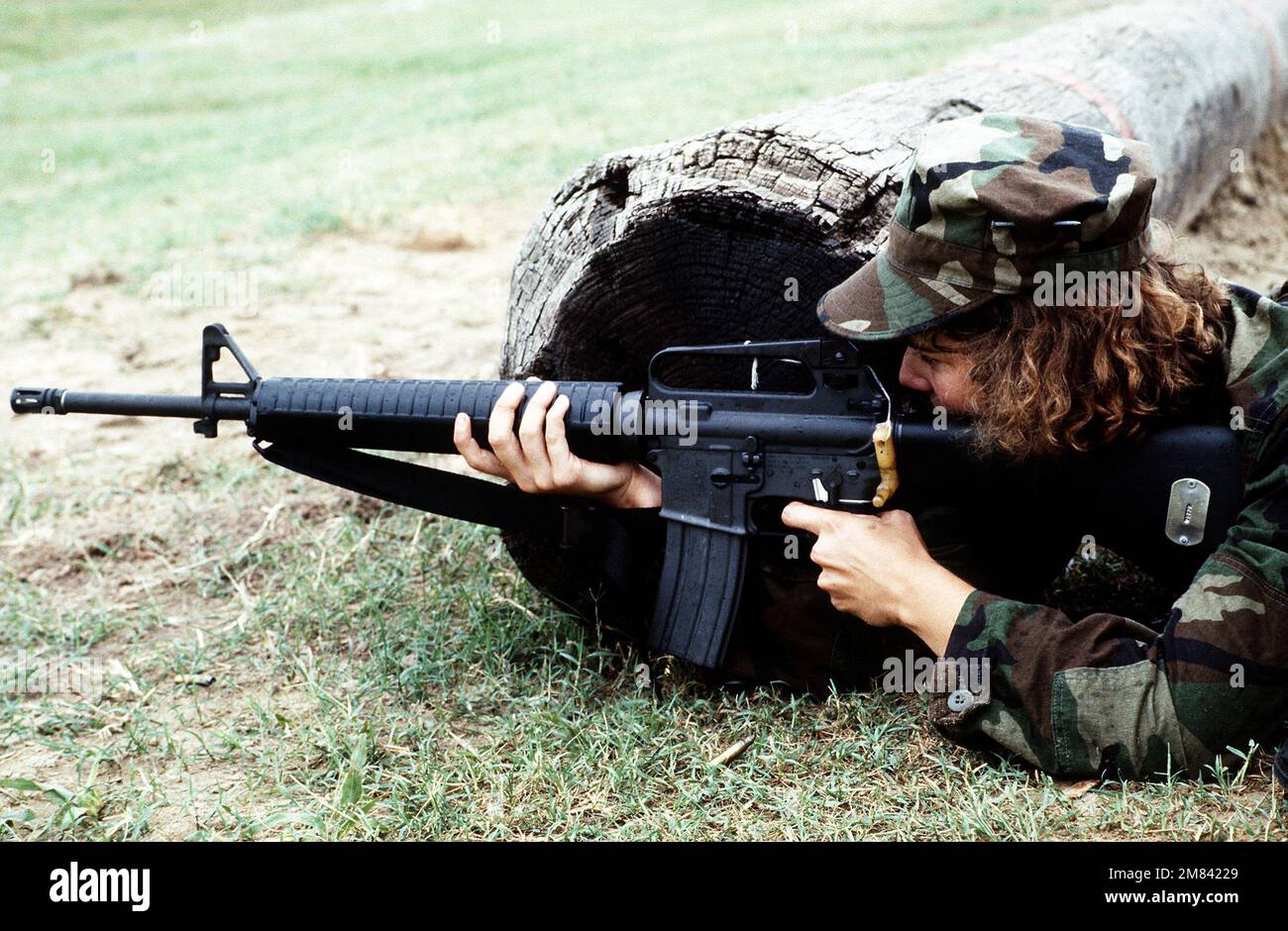 A woman Marine recruit fires an M-16A2 rifle from a prone position ...