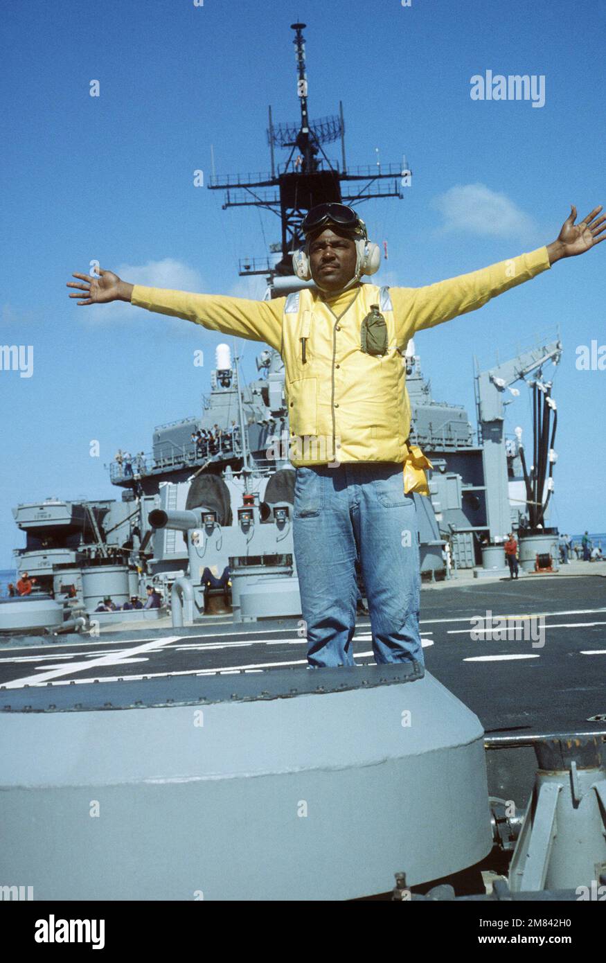 A landing director signals instructions to a helicopter during flight ...