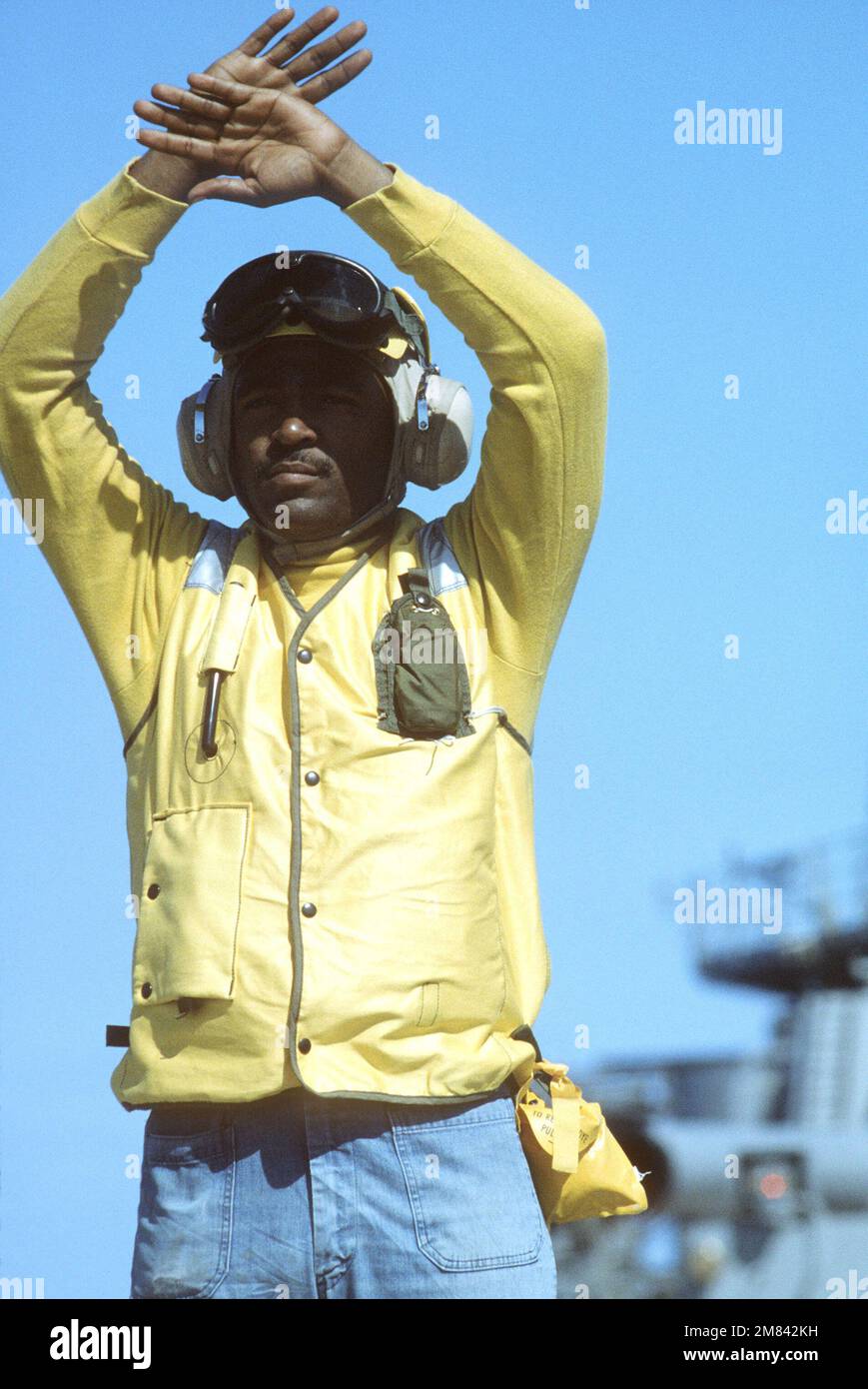 A landing director gives a helicopter the signal to hover during flight ...