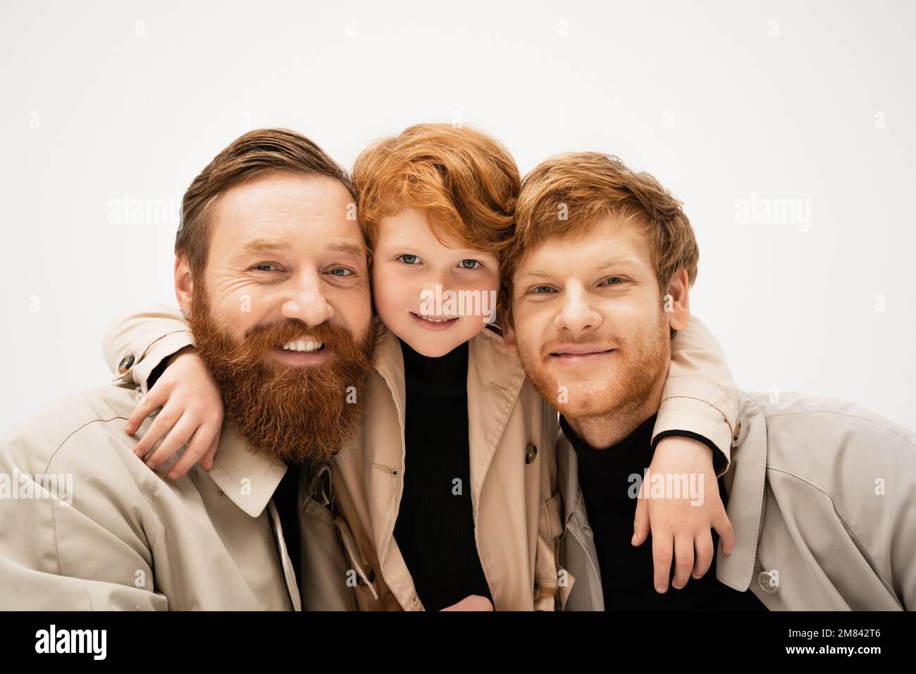 family portrait of red haired boy hugging cheerful bearded grandfather ...