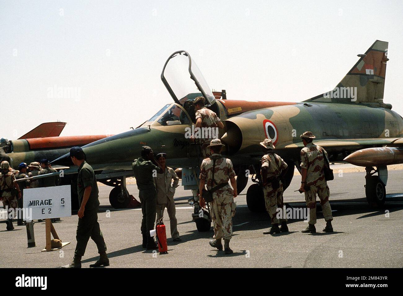 Military personnel inspect an Egyptian Mirage 5 aircraft on display ...