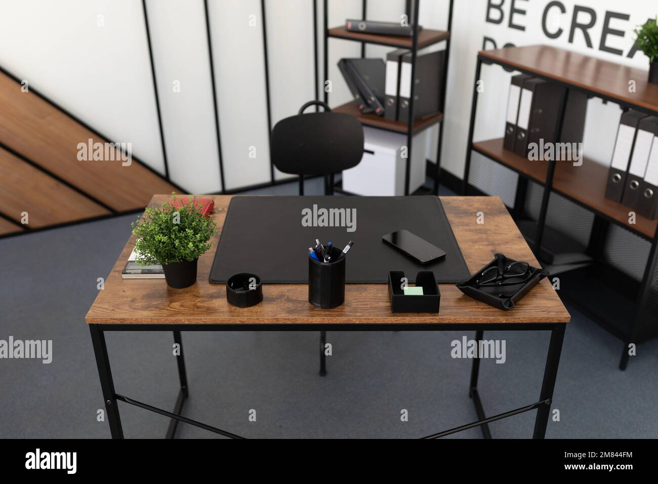 office desk in an empty office with office supplies and a leather pad ...