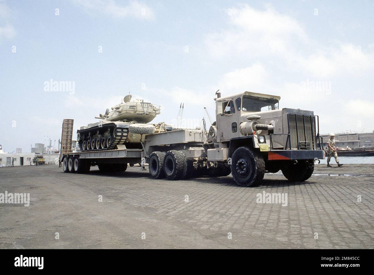 An Eqyptian tank transporter arrives at the dock with an M-60 main ...
