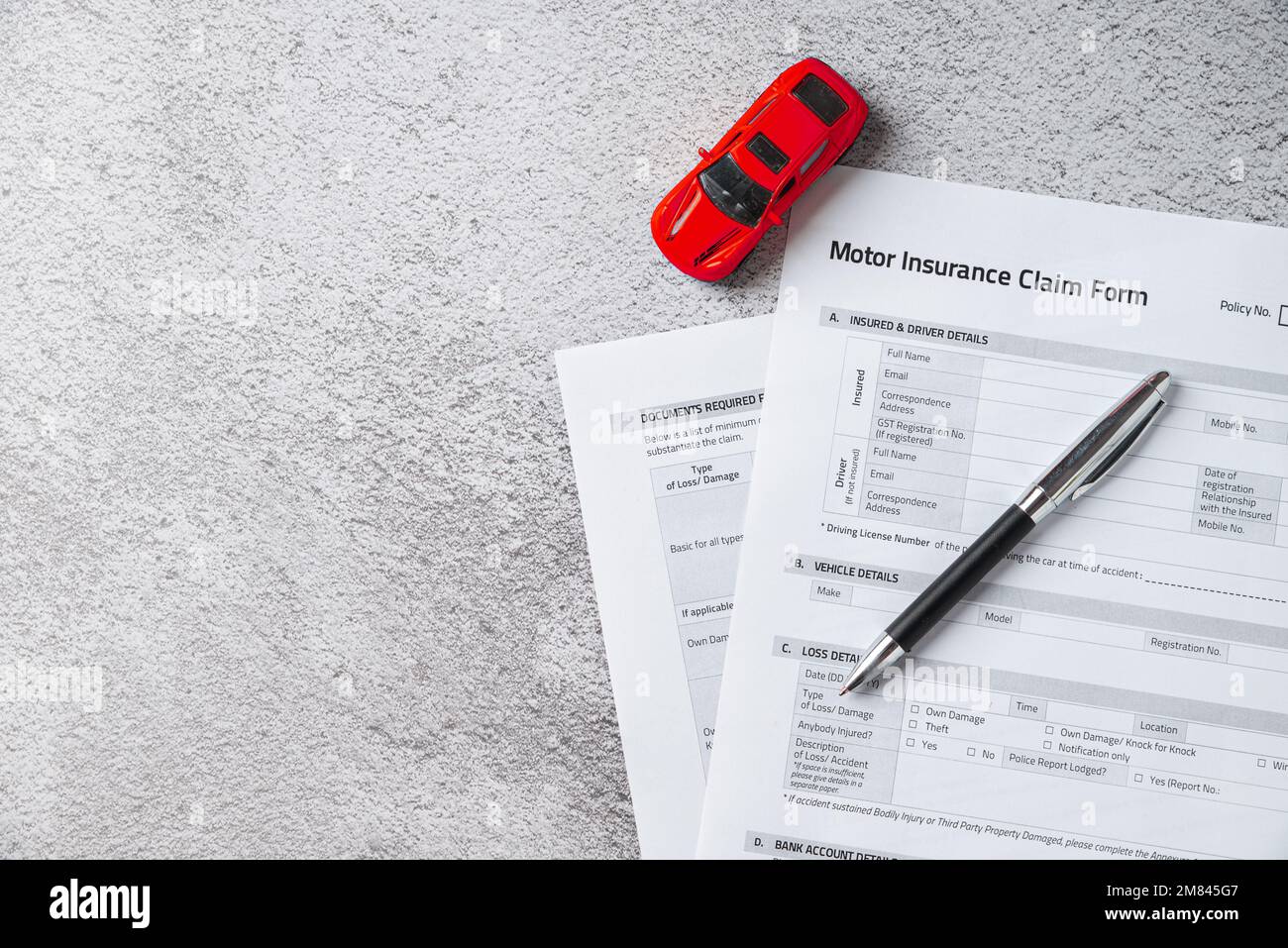 Motor or car insurance claim form with ballpoint pen and car model ...