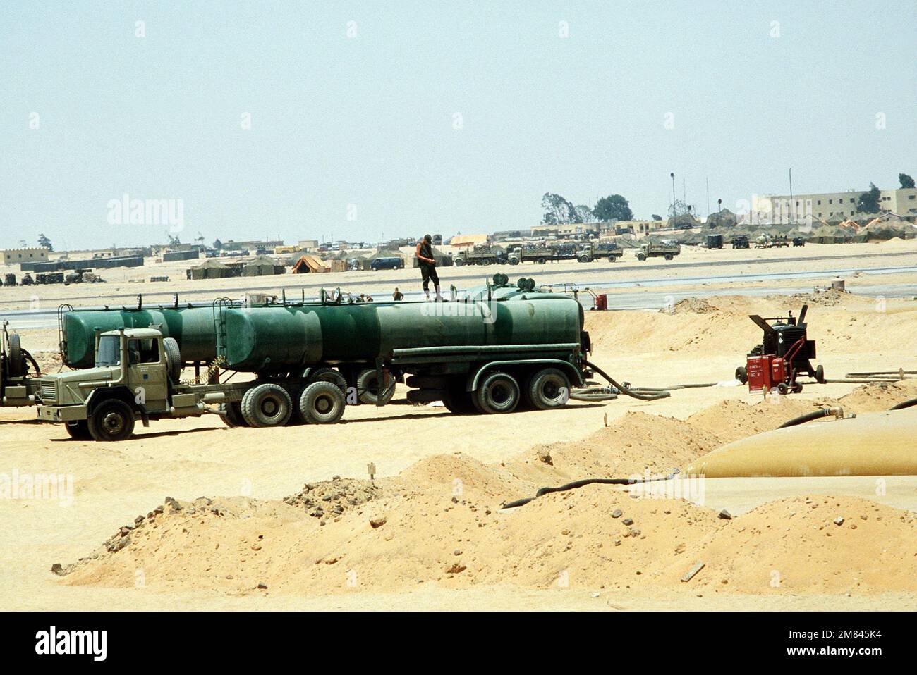 Egyptian fuel trucks fill fuel bladders on the flight line during the ...