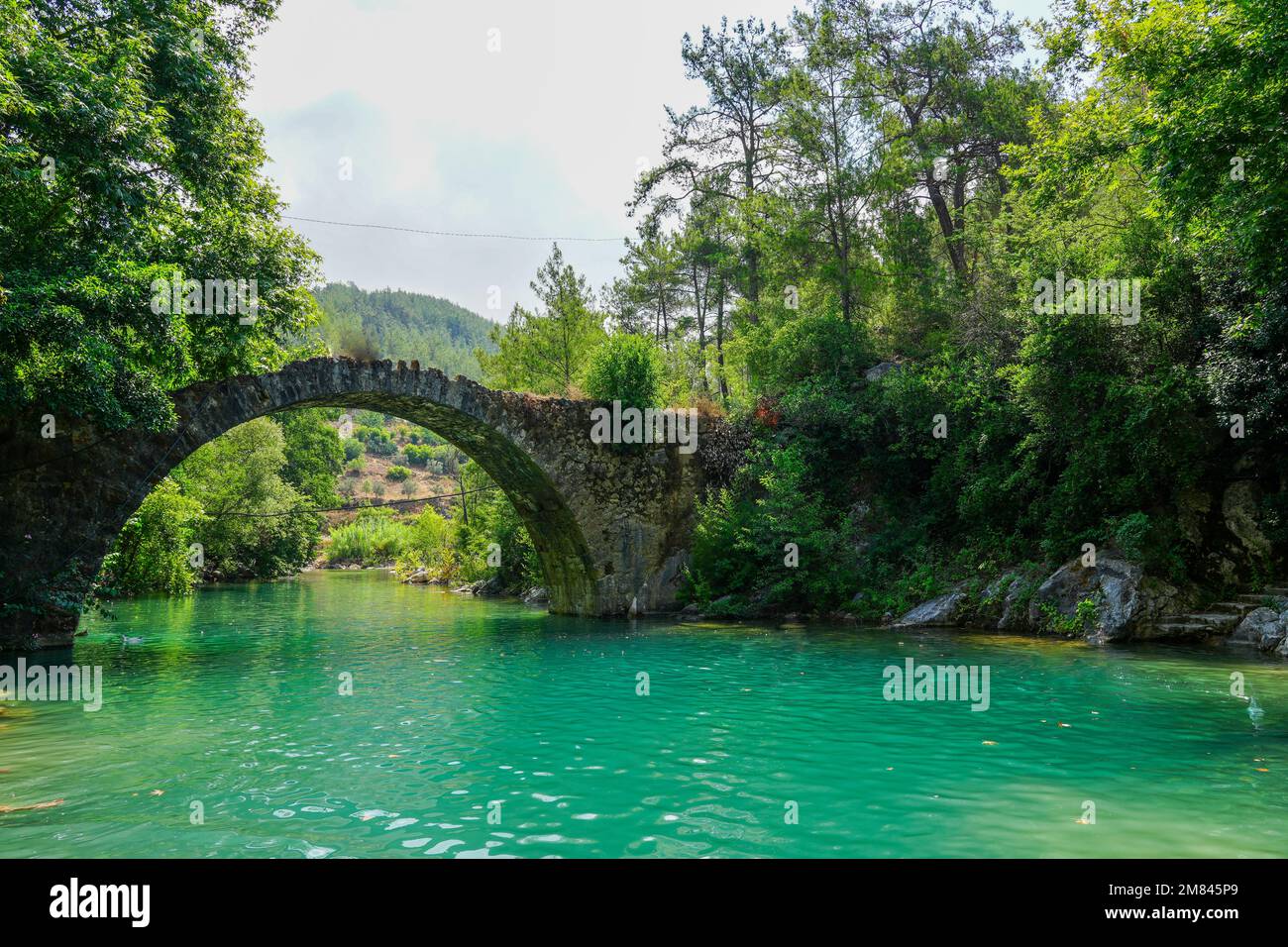Ancient roman bridge on Dim river in Turkey. Clear turquoise water and ...