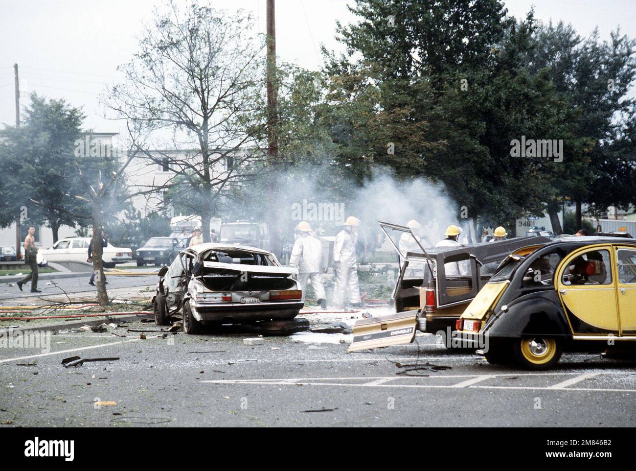 Firefighters check for further damage after a car loaded with a bomb ...