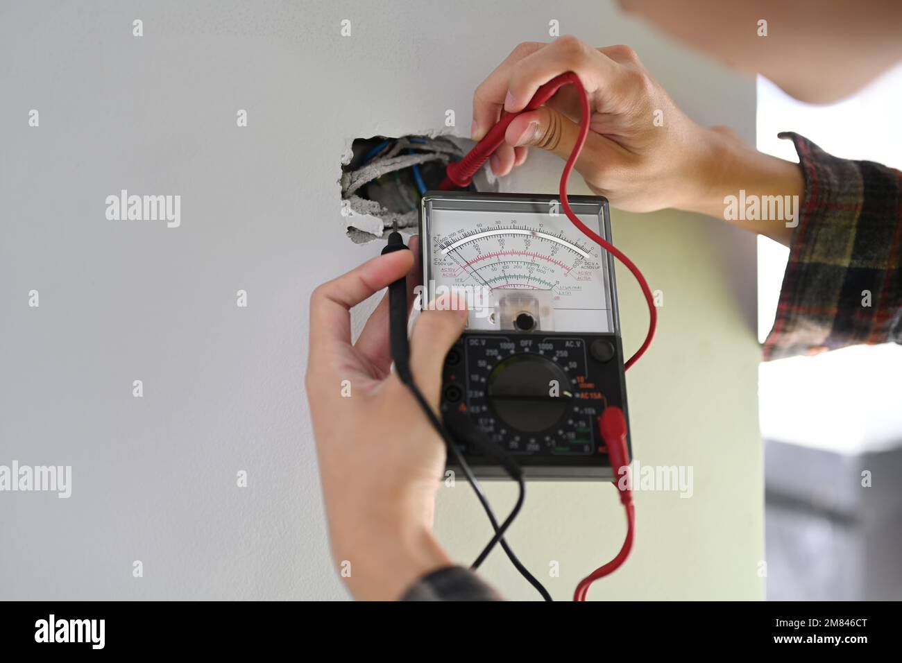 Cropped shot of electrician using a multimeter to test the electrical ...