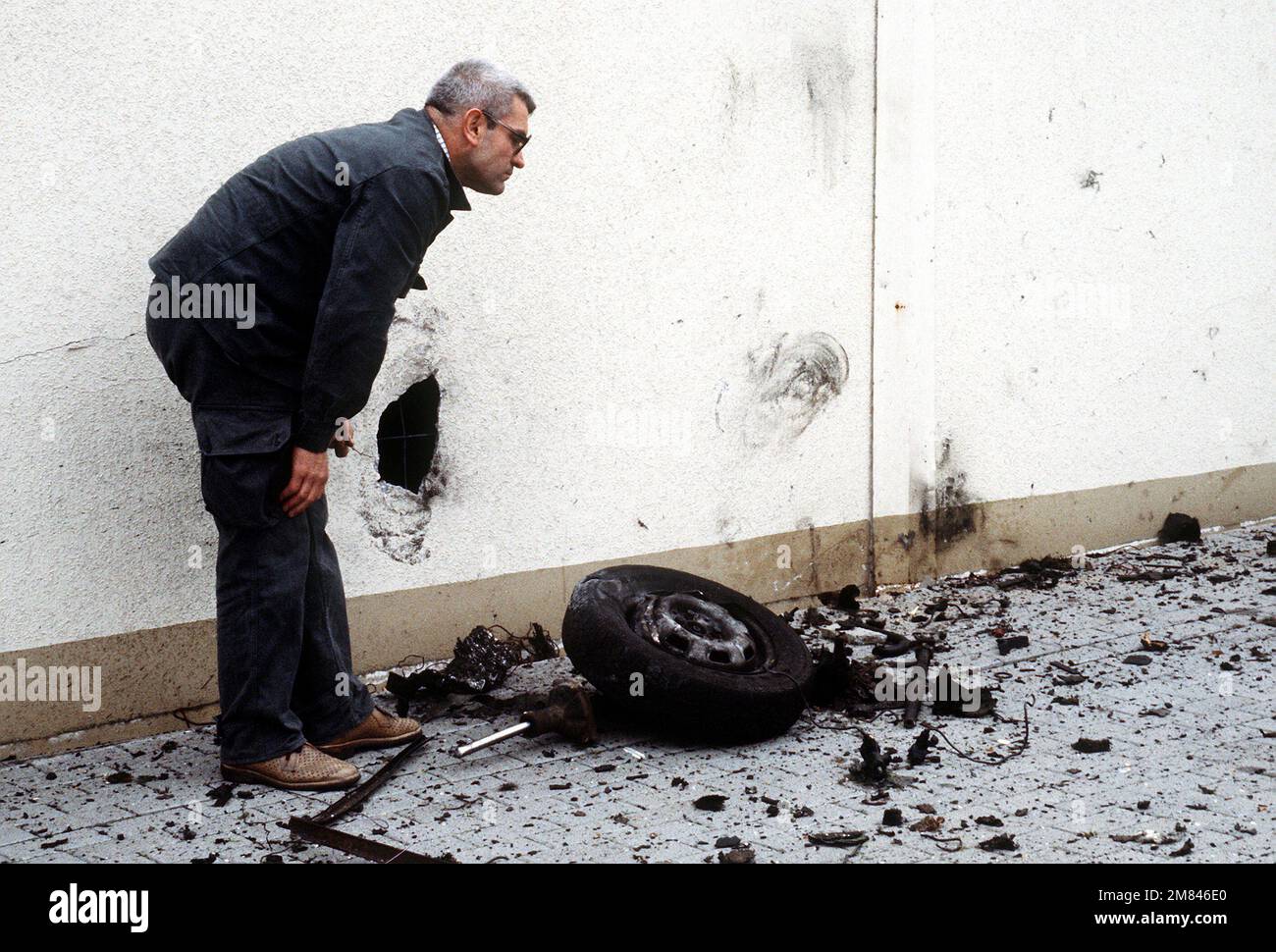 A German explosives expert investigates the area after a car carrying a ...